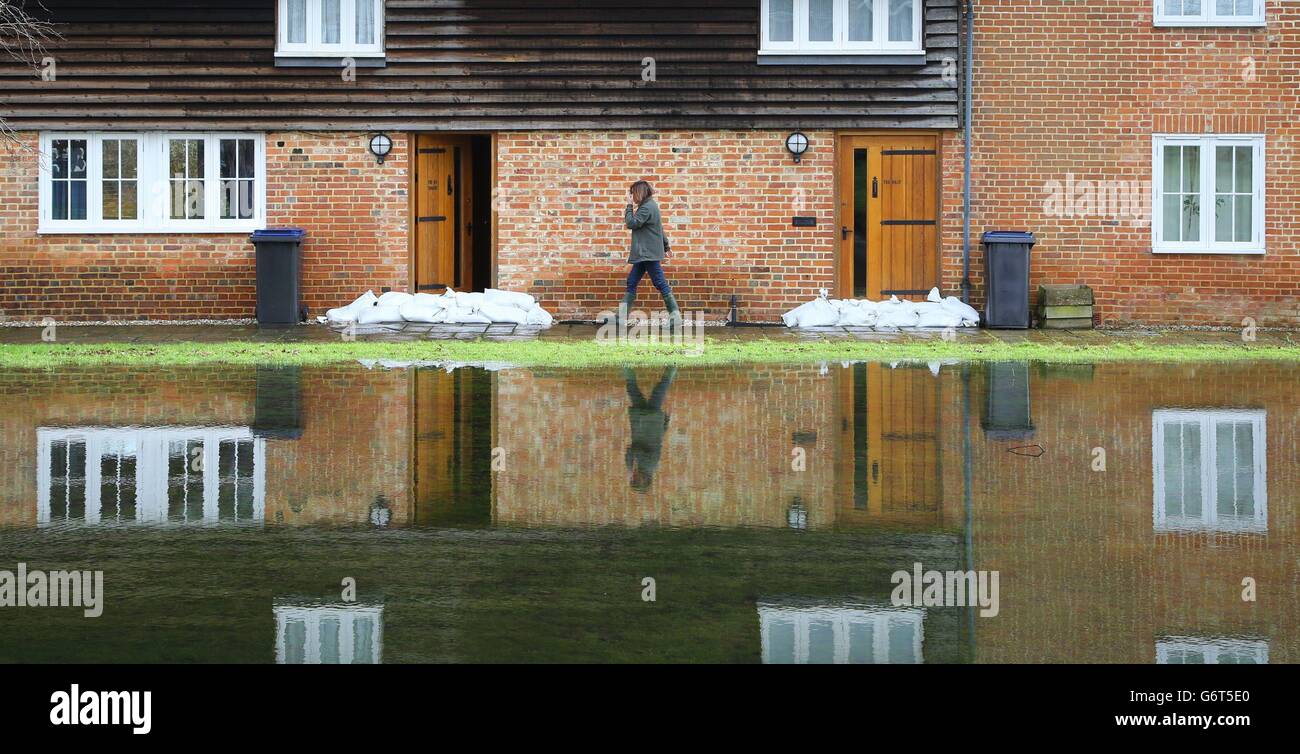 A woman walks past her oast house in Littlebourne, Kent, as river ...
