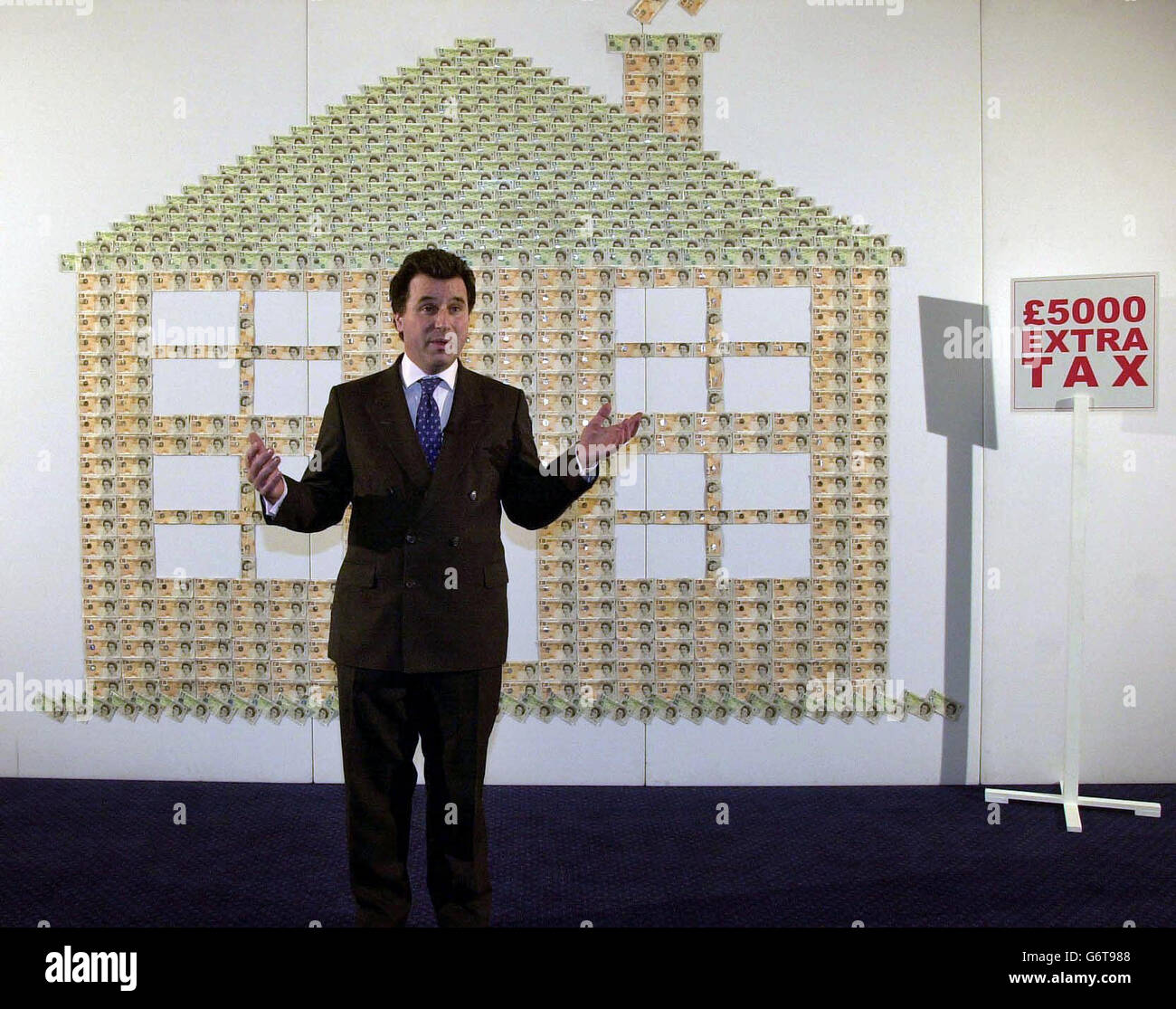 Shadow Chancellor Oliver Letwin, standing against a wall of banknotes ...