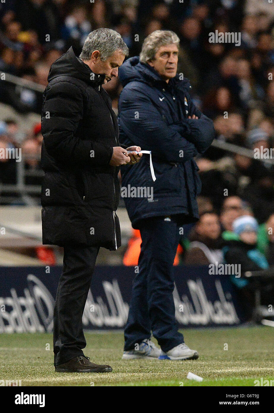 Chelsea's Manager Jose Mourinho (left) looks at his notepad next to ...