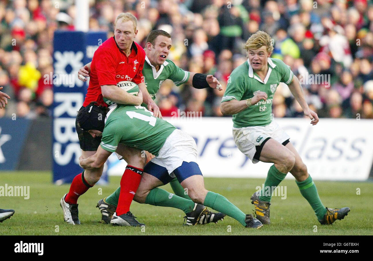 Wales' Tom Shanklin (left) is tackled by Ireland's Tyrone Howe and ...