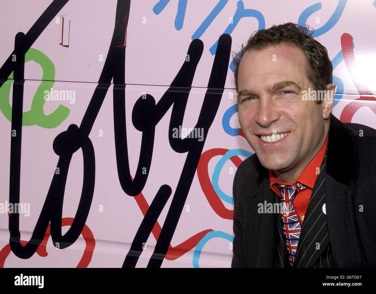Fashion designer Toby Mott poses for photographers in a London bus ...
