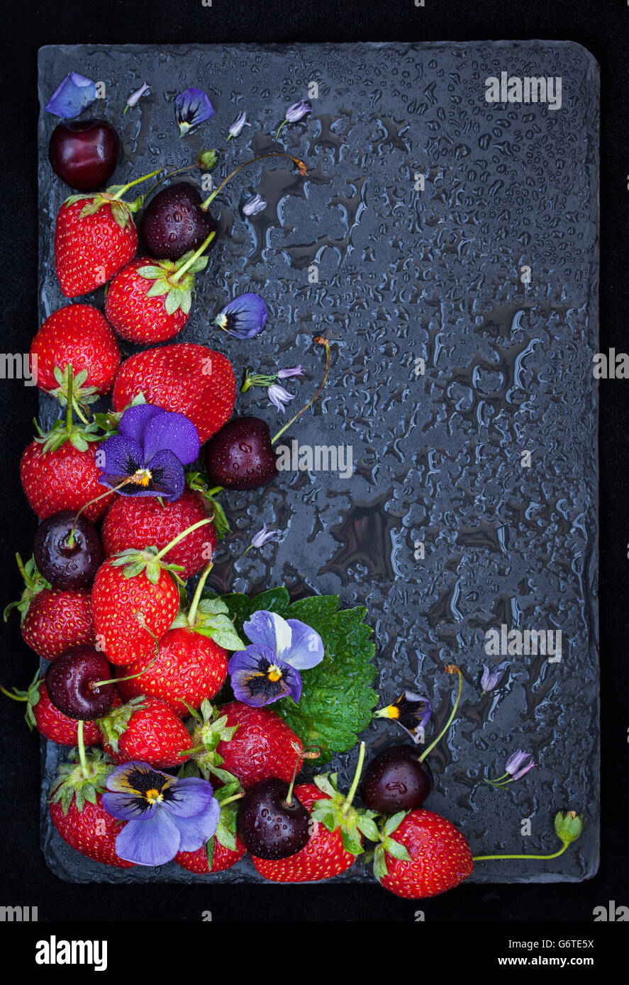 Fresh summer ripe strawberry and cherry on dark background, decorated ...