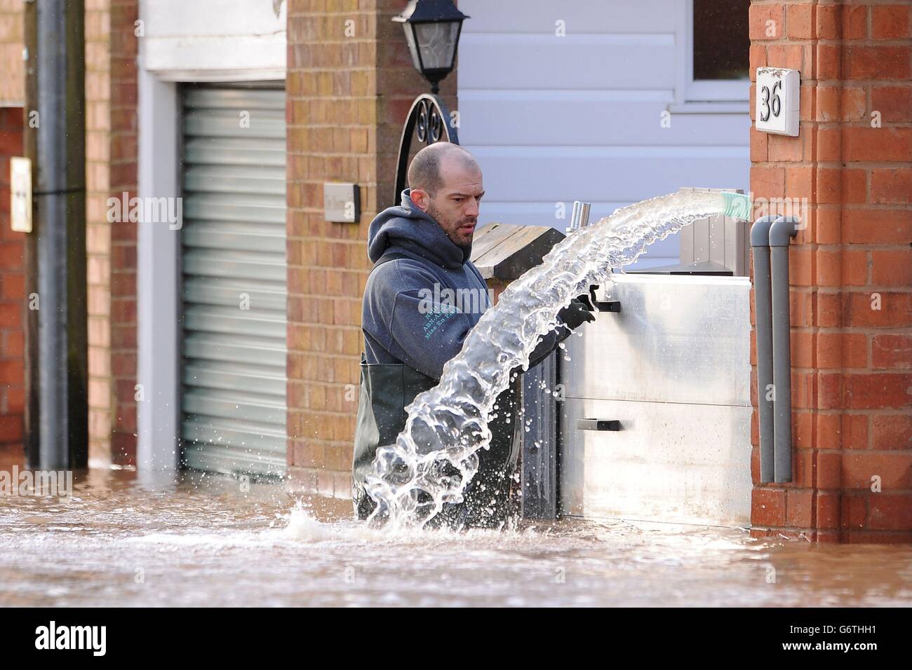 Christian Gander makes his way through floodwater as he leaves his home ...