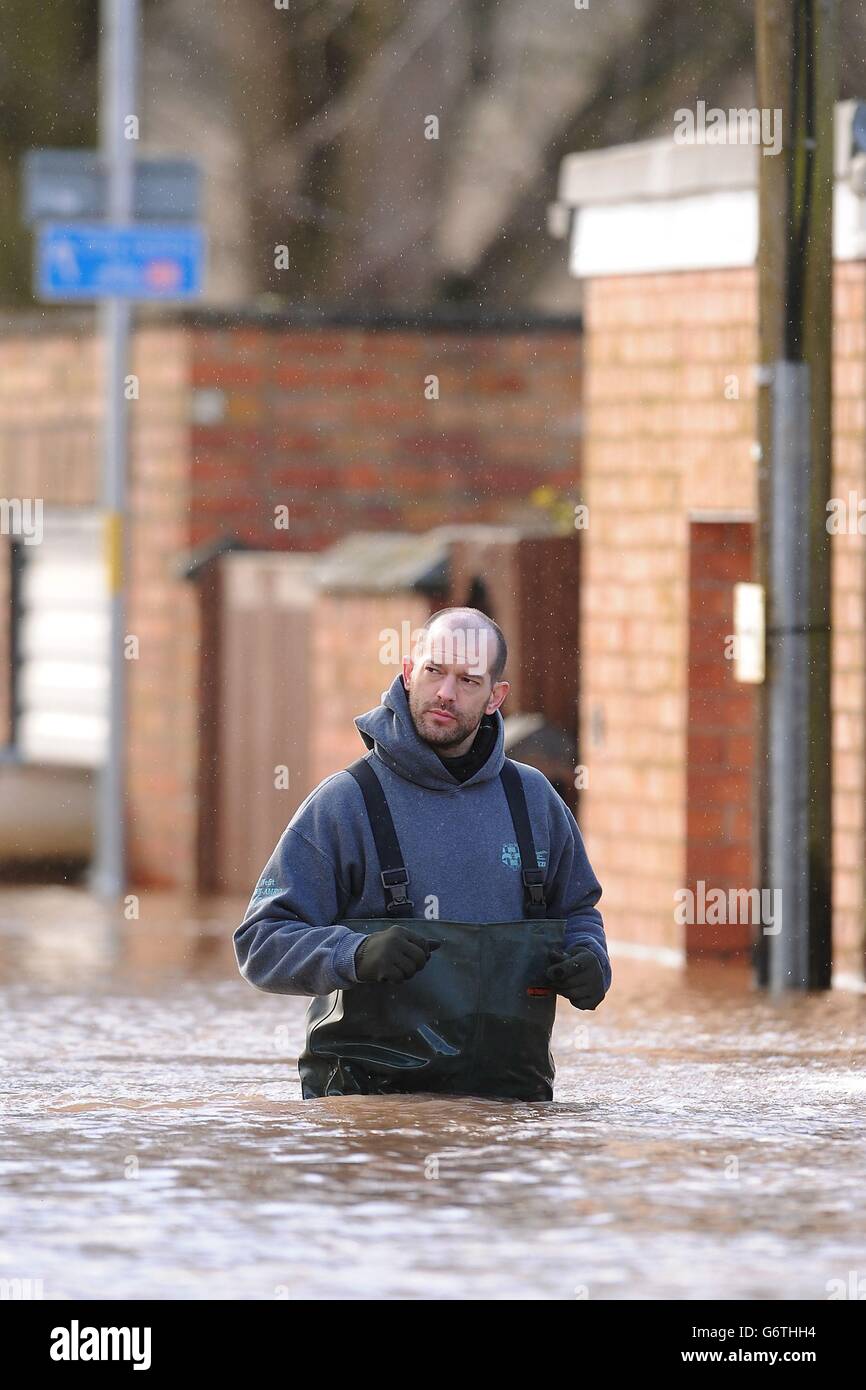 Christian Gander makes his way through floodwater as he leaves his home ...