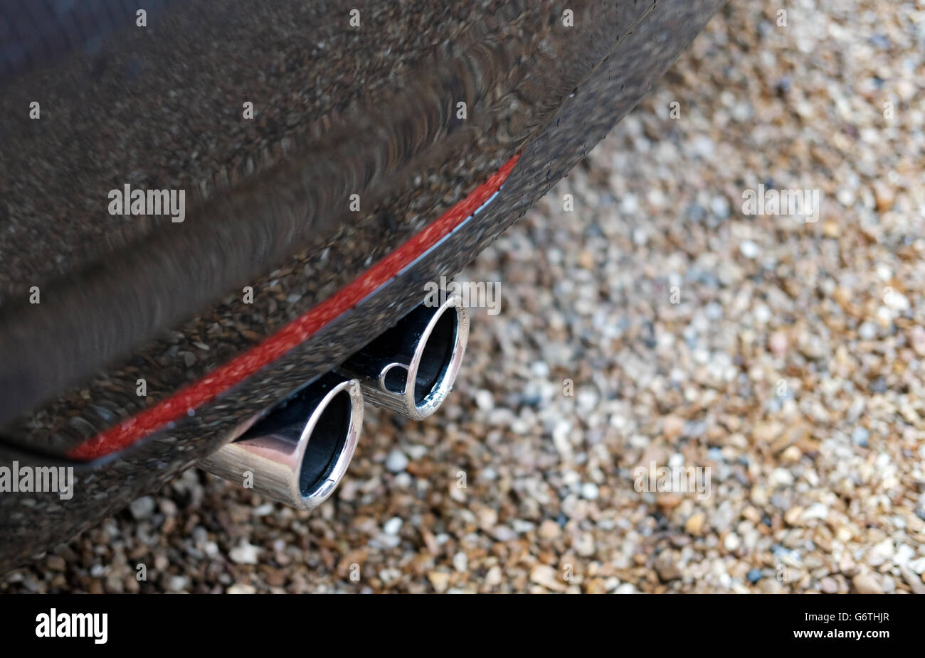 Twin chrome car exhaust pipes seen on the back of a car Stock Photo - Alamy