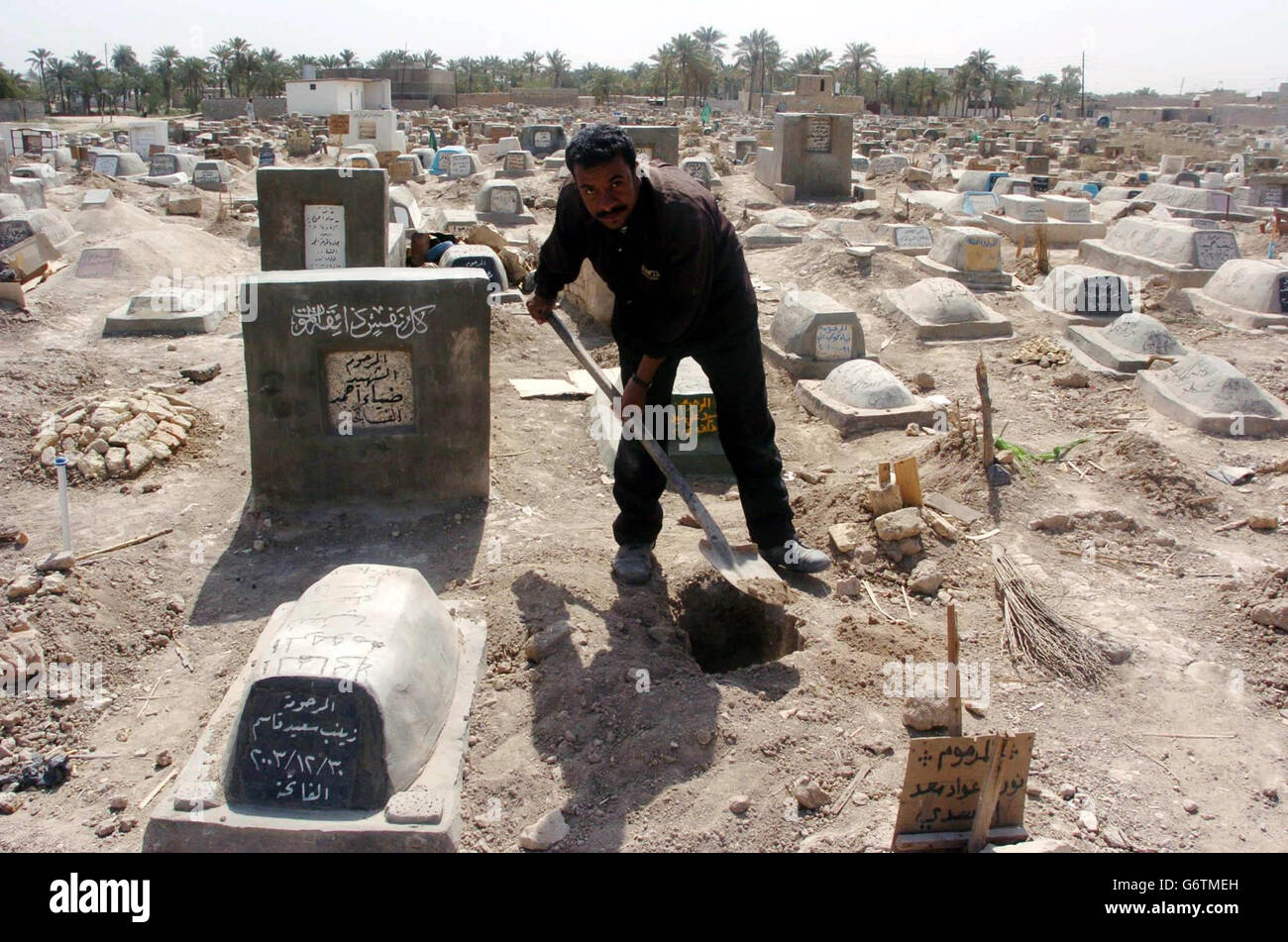 An Iraqi man digs a grave intended for an infant at a cemetery in ...