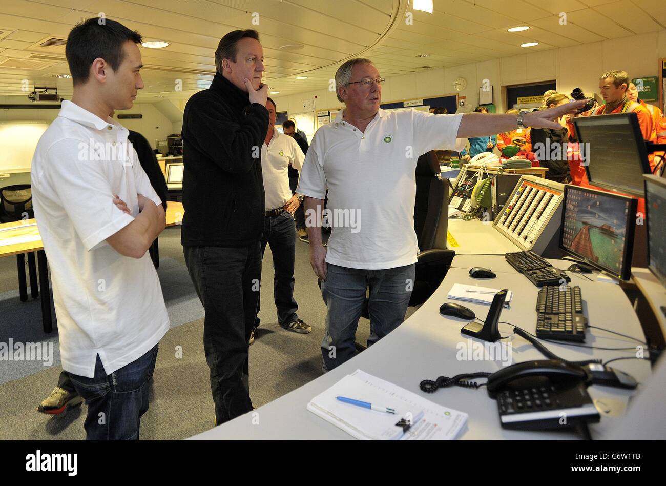 Prime Minister David Cameron (centre) talks with workers during a visit ...