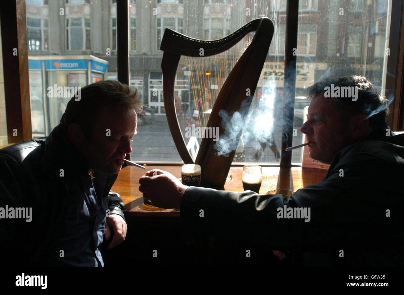 Two men smoking in The Oval Bar on Middle Abbey Street, Dublin, Ireland ...