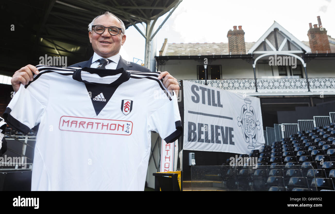 Fulham manager Felix Magath holds up a Fulham shirt following his first ...
