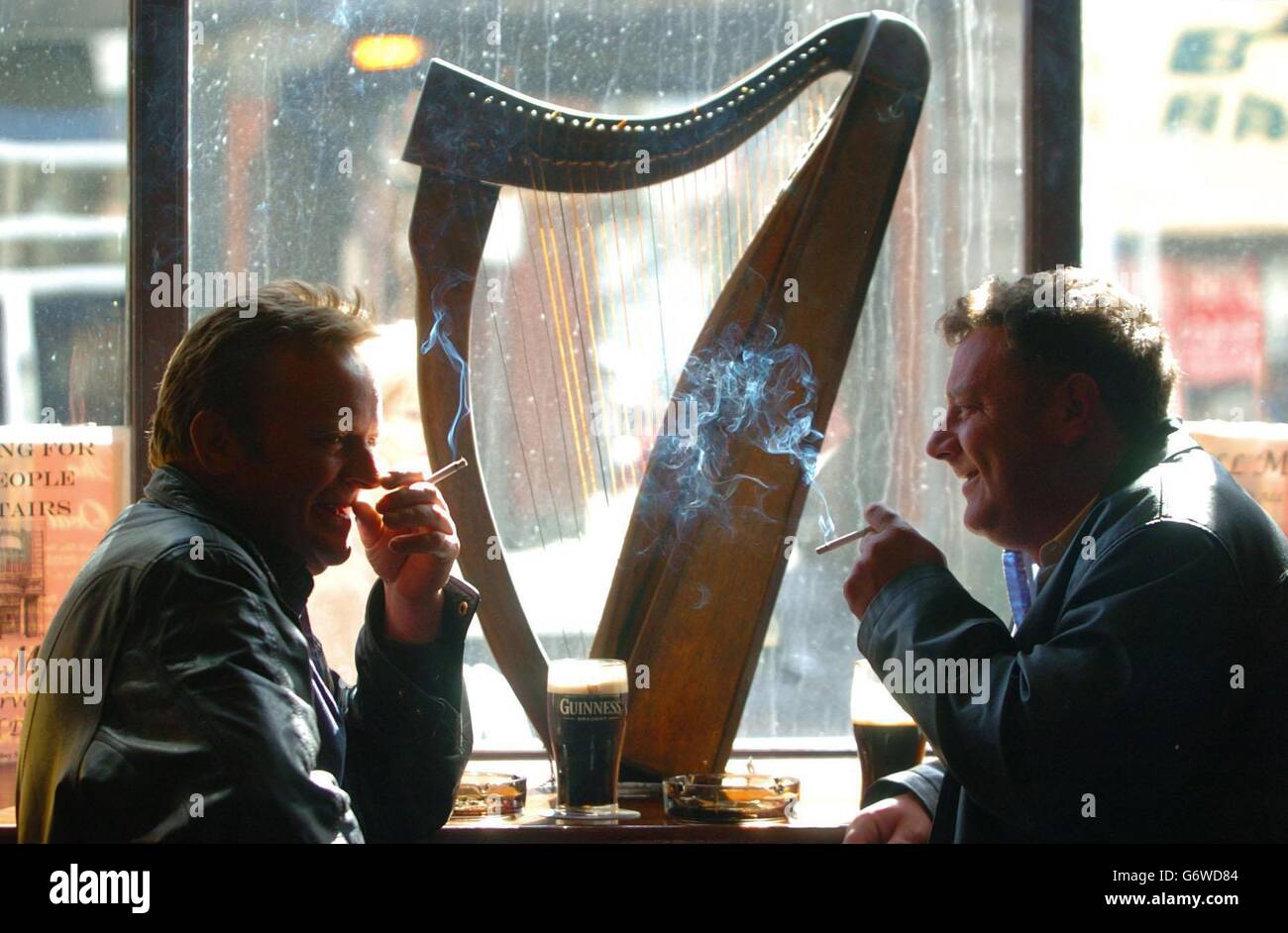 Two men smoking in The Oval Bar on Middle Abbey Street, Dublin, Ireland ...