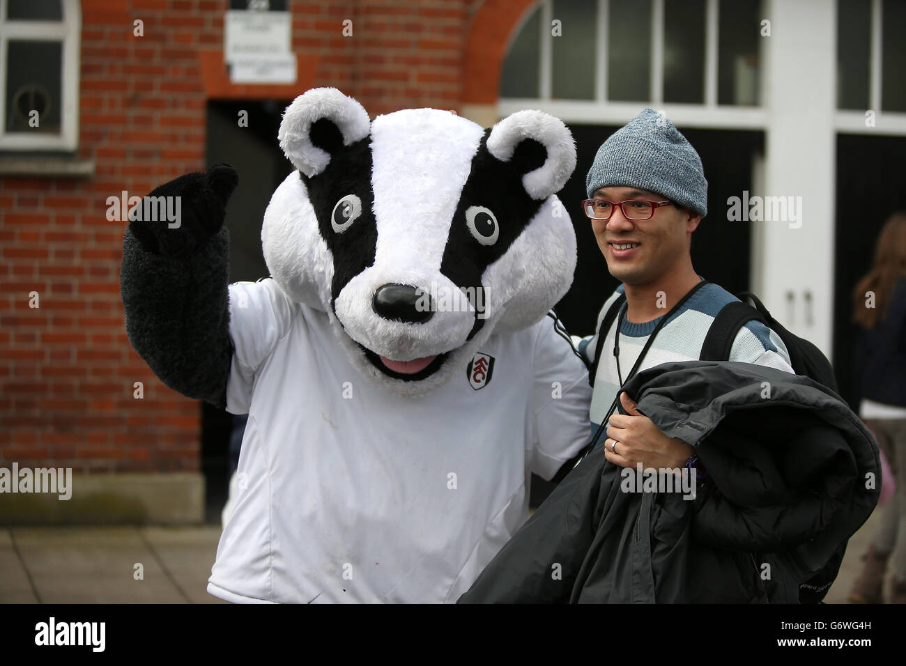 Fulham mascot Billy the Badger with a fan outside Craven Cottage Stock ...