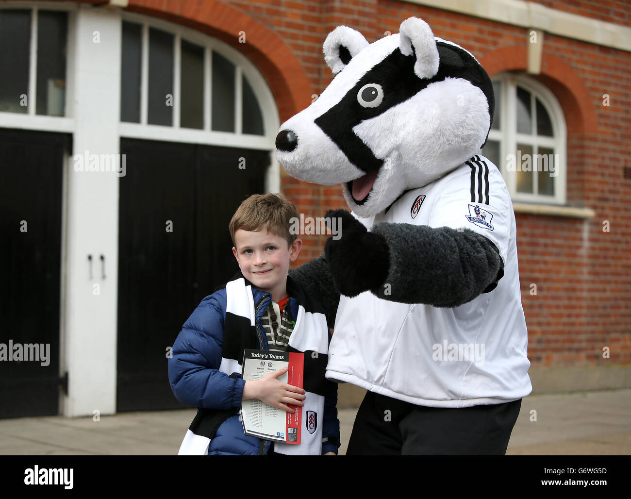 Fulham mascot Billy the Badger with a fan outside Craven Cottage Stock ...