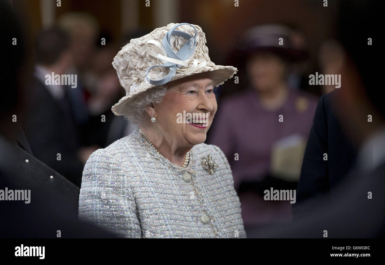 Queen elizabeth ii smiles as she visits reeds school hi-res stock ...