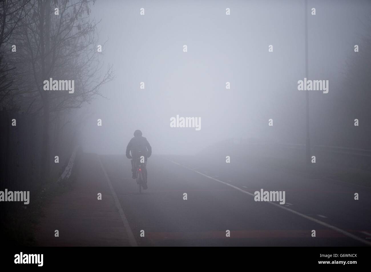 A cyclist makes their way through fog at Heathrow Airport, as number of ...