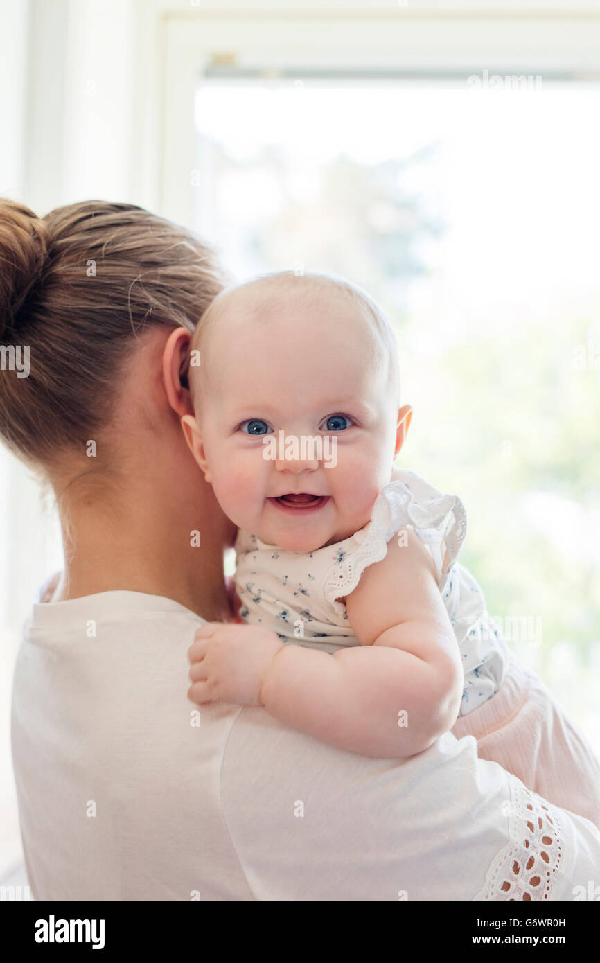 Smiling and cute baby girl with her caring mother Stock Photo - Alamy