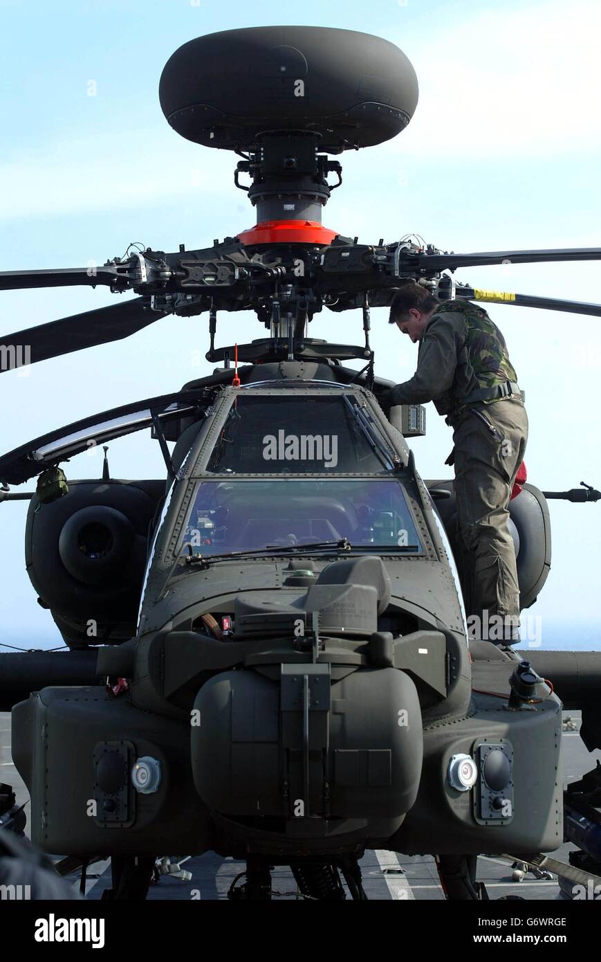 An Apache attack helicopter is prepared for flight aboard HMS Ocean in ...
