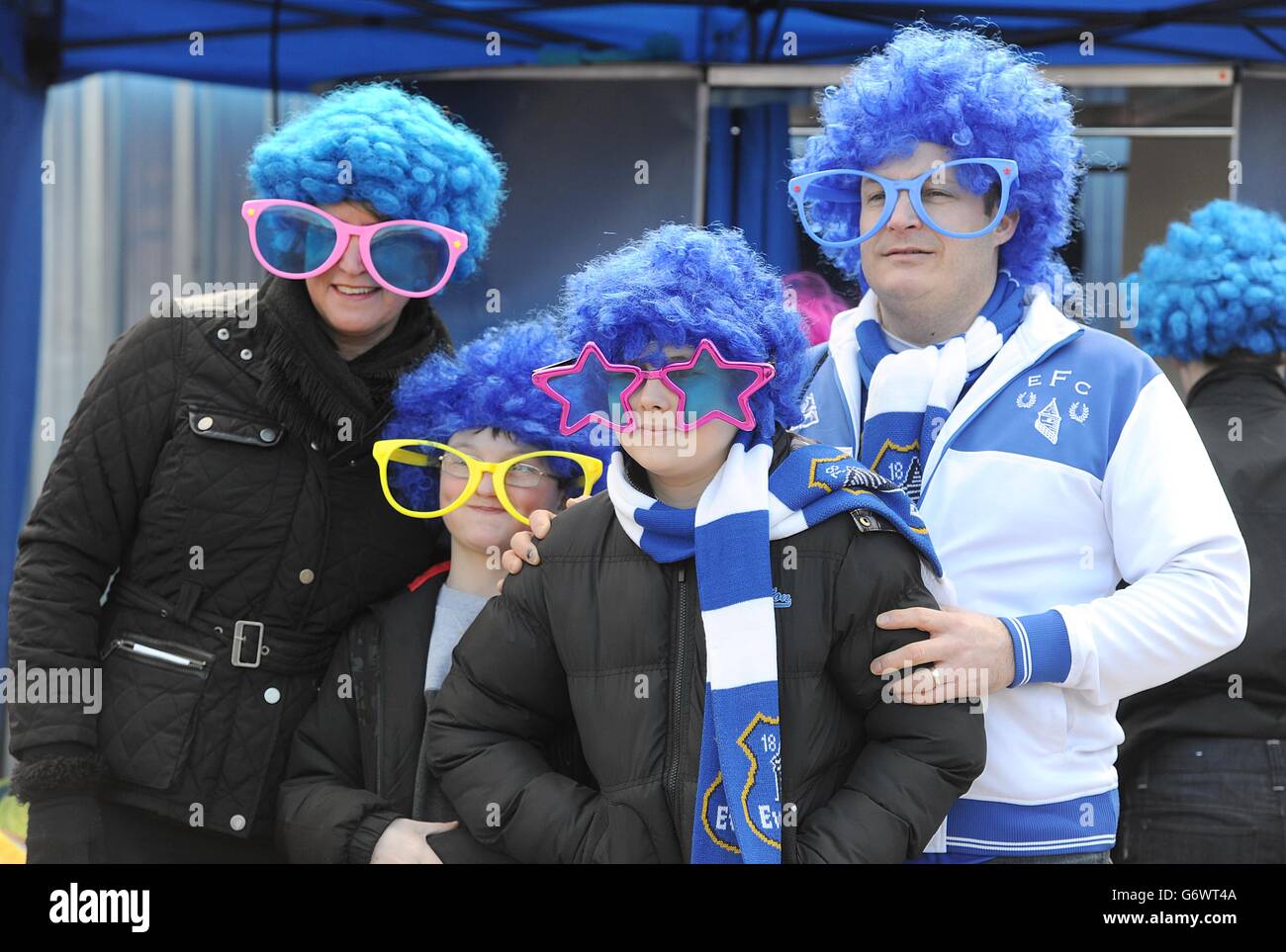 Everton fans pose wearing glasses and wigs in the fan zone Stock Photo ...