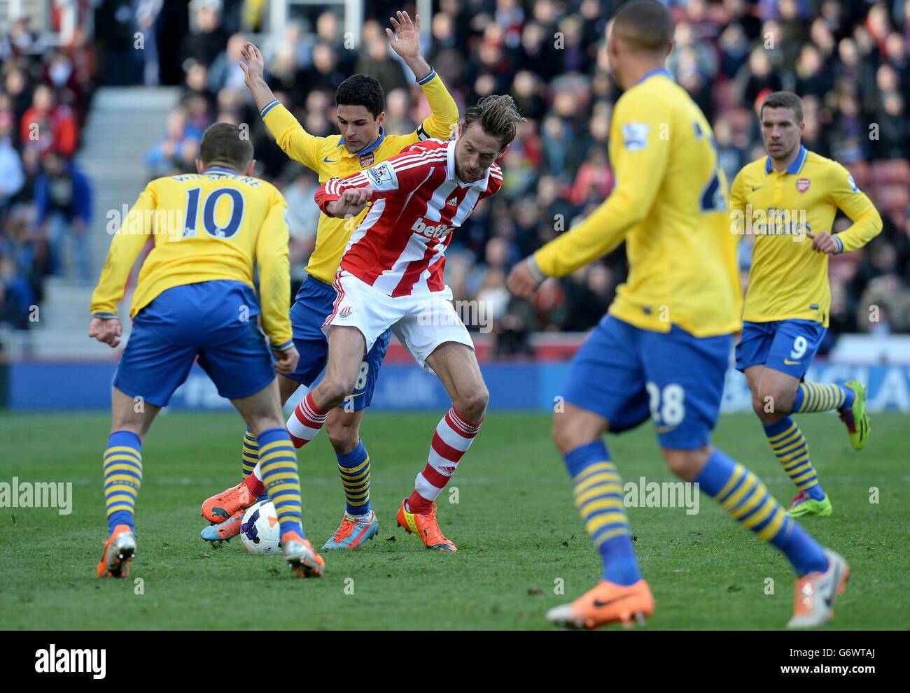 Stoke City's Peter Crouch battles for the ball with Arsenal's Mikel ...