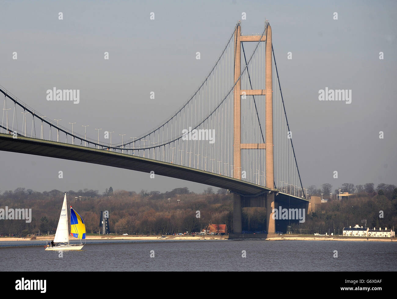 A sailing boat goes under the Humber Bridge on the Humber estuary, near ...