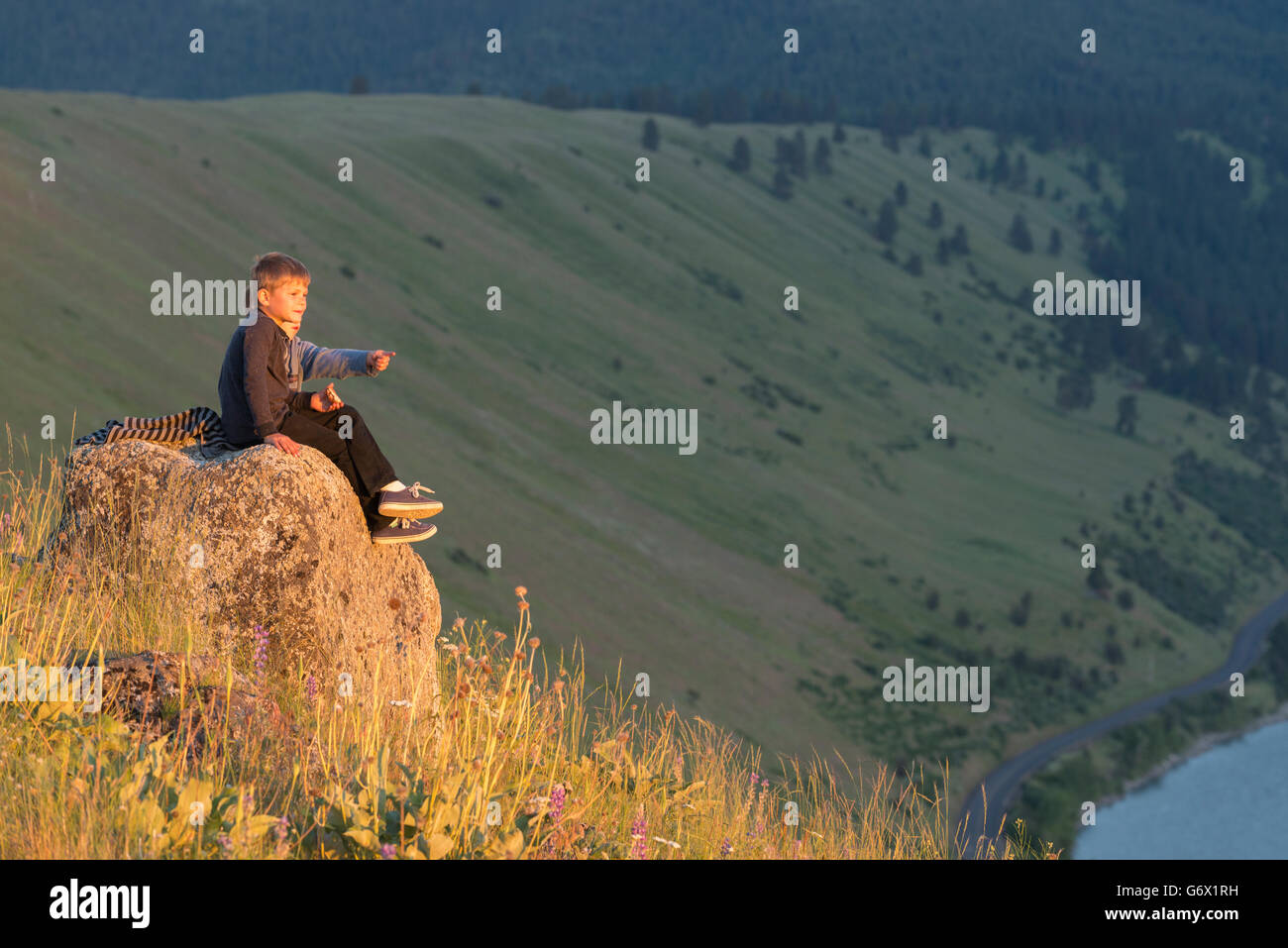 Boys sitting on a boulder on the Wallowa Lake moraine in Oregon's ...