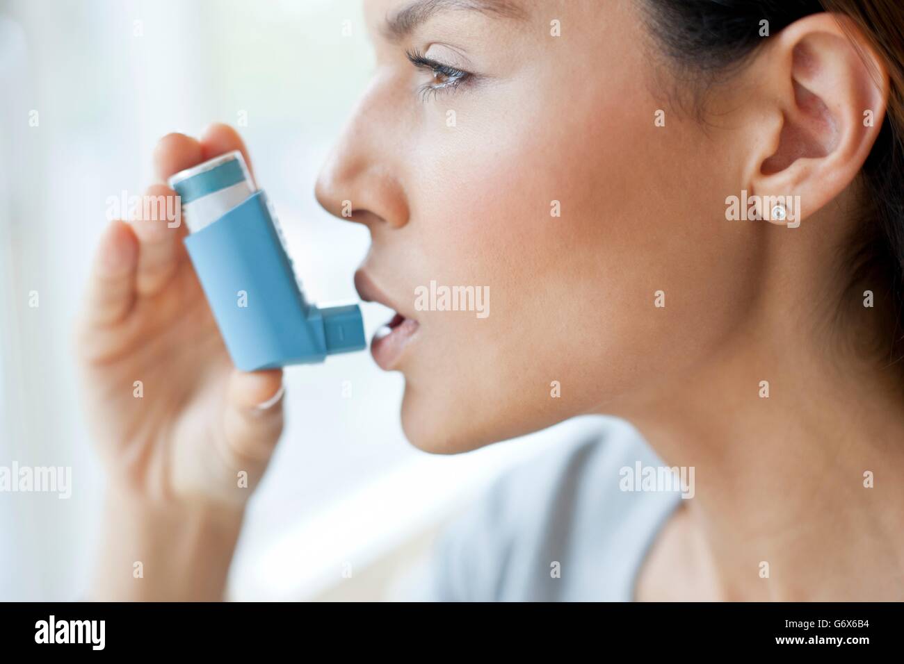 MODEL RELEASED. Young woman using an inhaler Stock Photo - Alamy