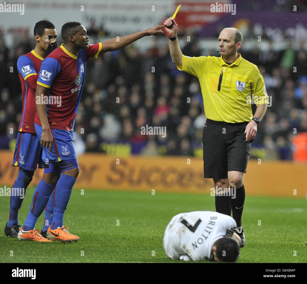 Referee Mike Dean shows a yellow card to Crystal Palace's Mile Jedinak ...
