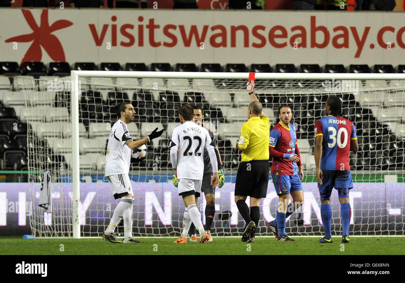 Referee Mike Dean shows a Red card to Swansea City's Chico Flores ...