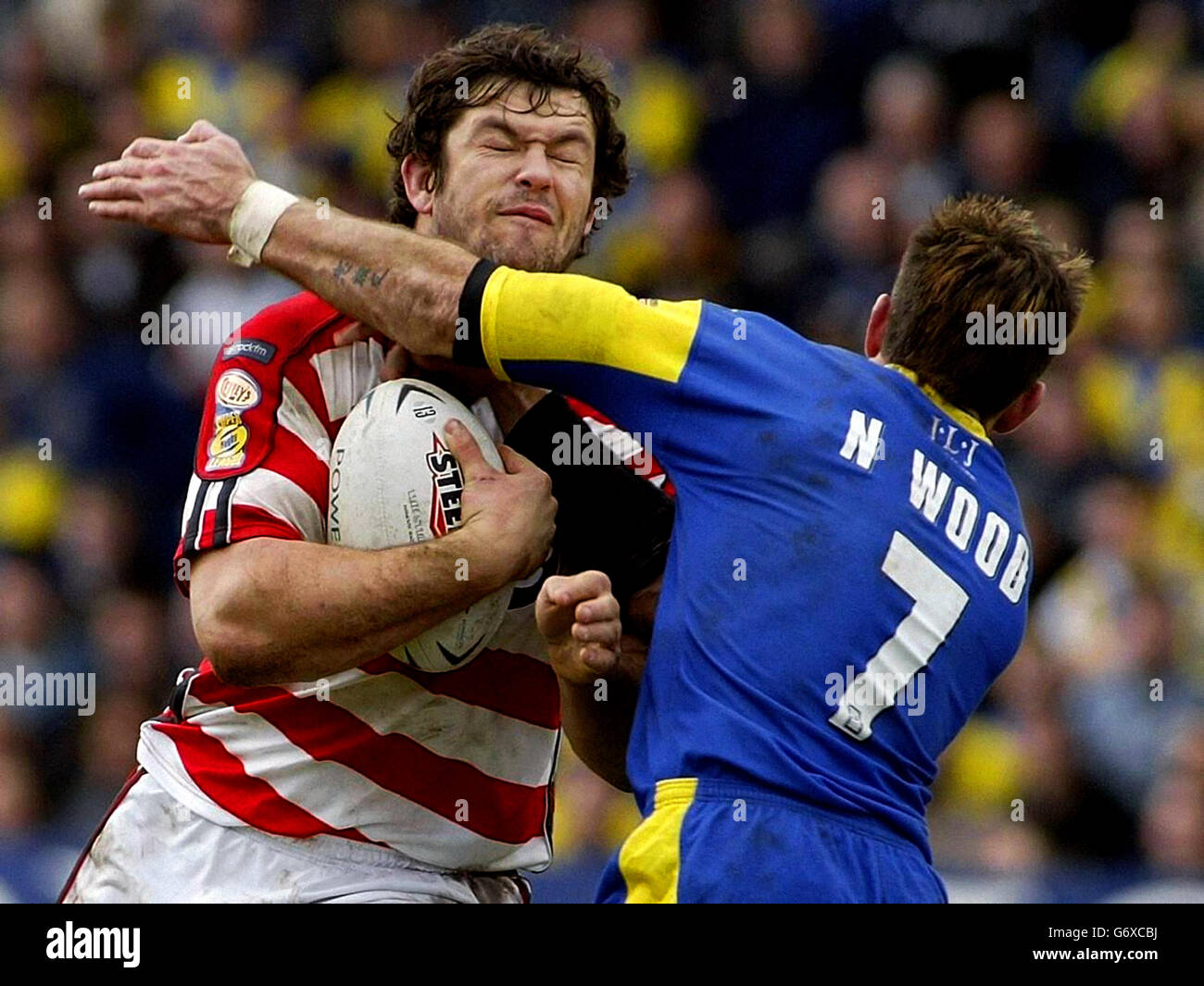 Wigan's Andrew Farrell is tackled by Warrington's Nathan Wood during ...