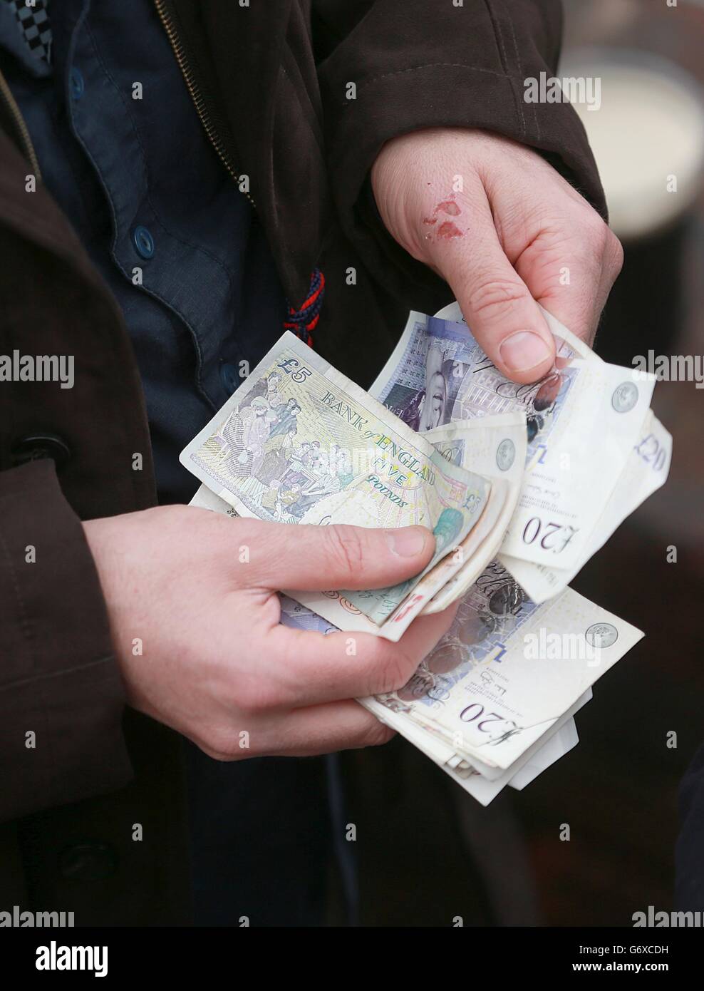 A racegoer counts his money on Ladies Day before racing, during the ...