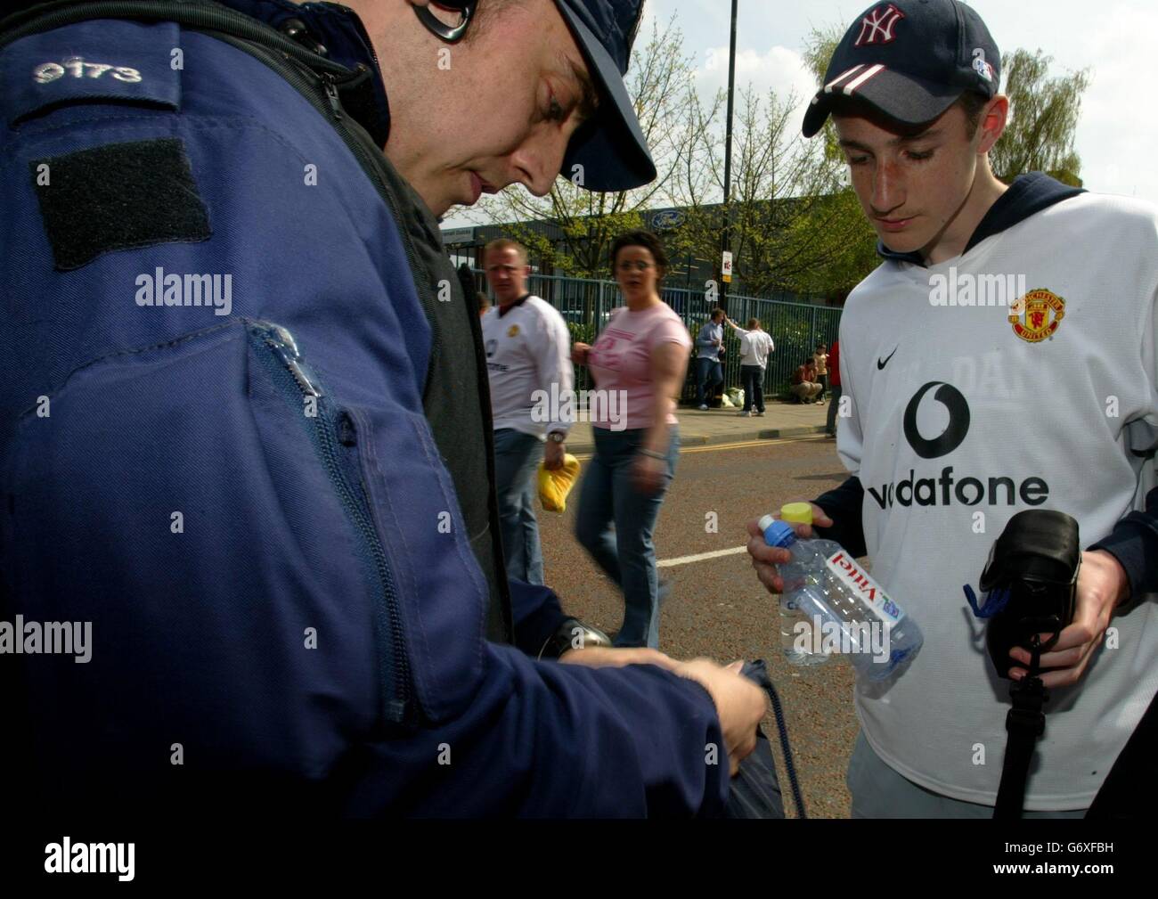Police officers search a Manchester United fan ahead of the Barclaycard ...