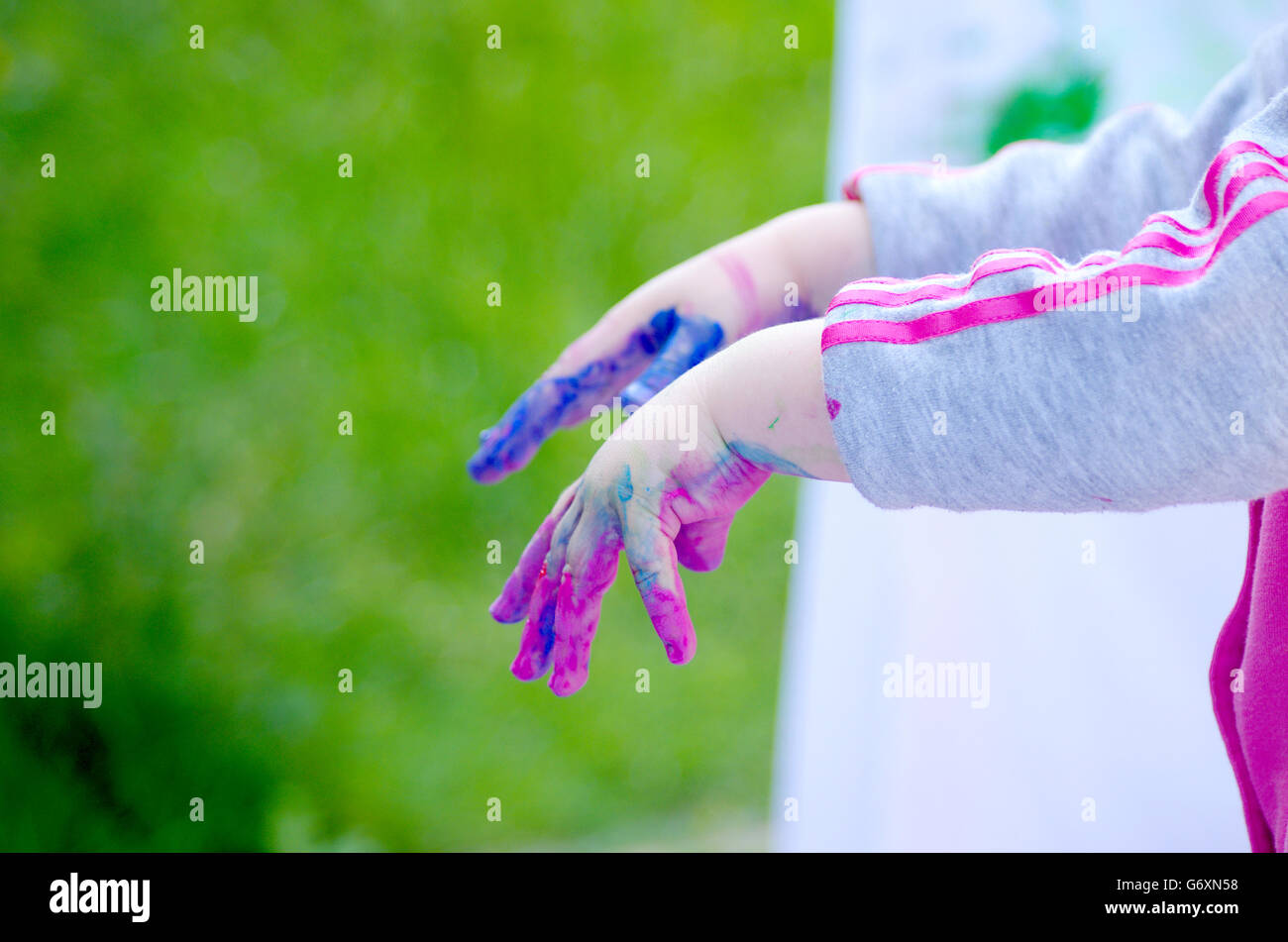 children playing making colorful designs with hands dipped in colored ...