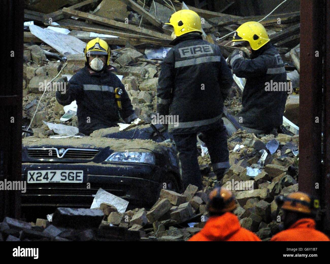 Firefighters continue early to comb the wreckage of a four storey ...