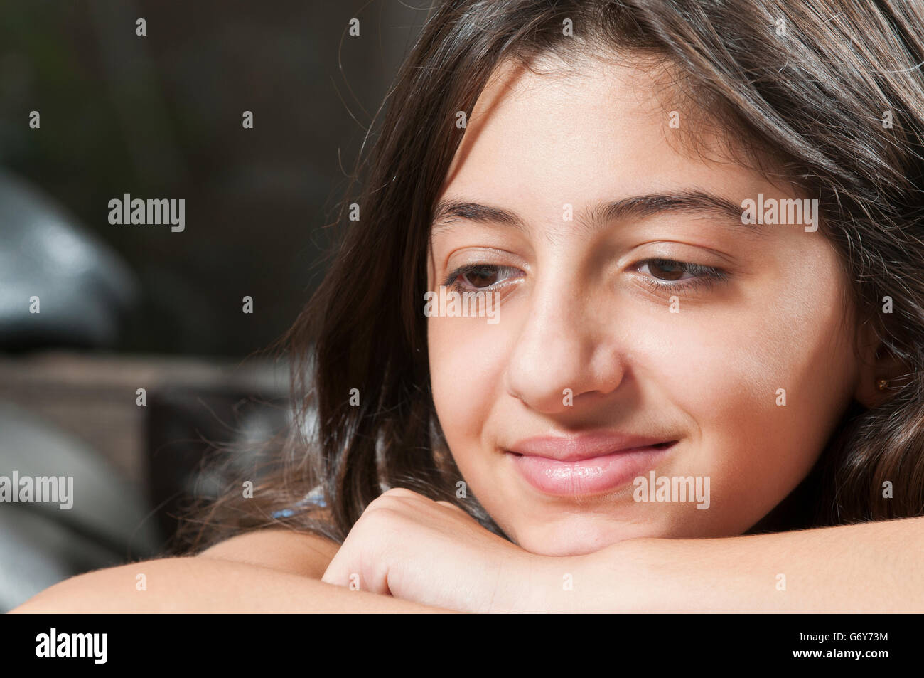 Close up of a beautiful girl leaning on hands looking away smiling ...