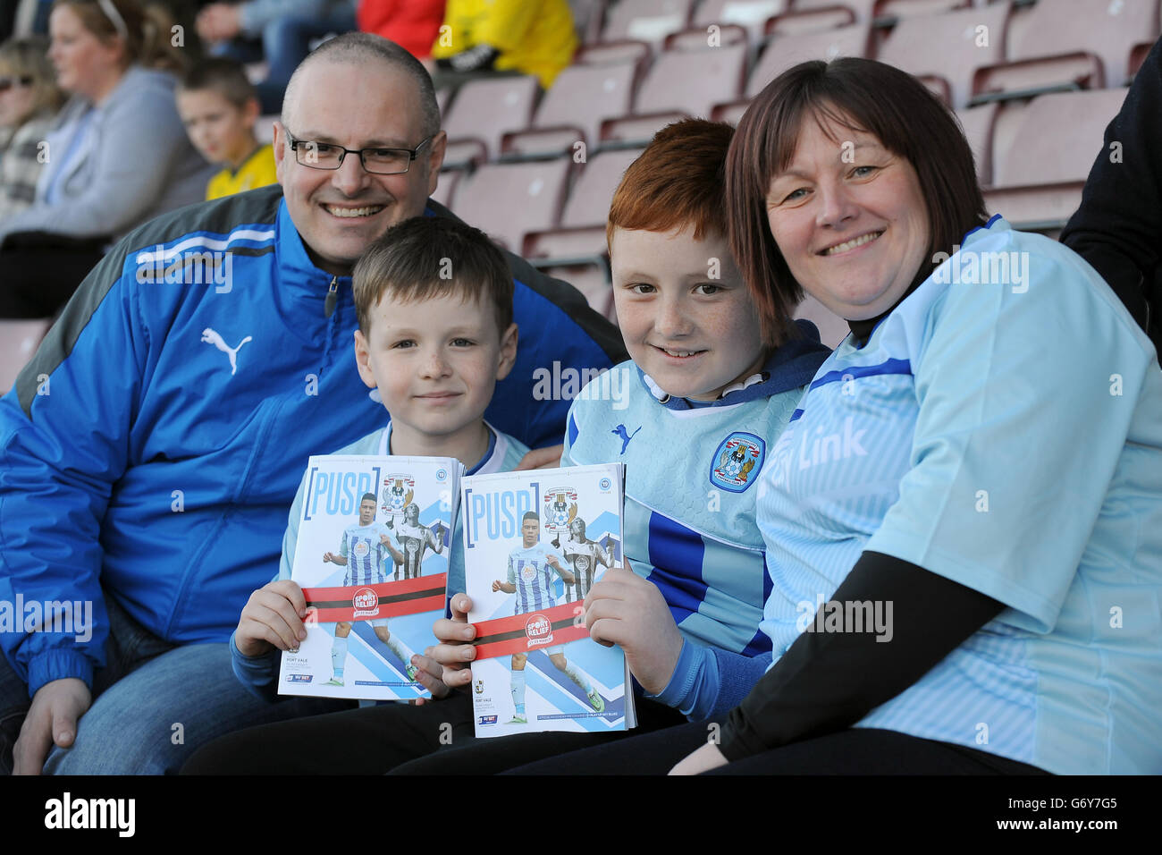Fans in the stands pose with their match day programmes Stock Photo - Alamy
