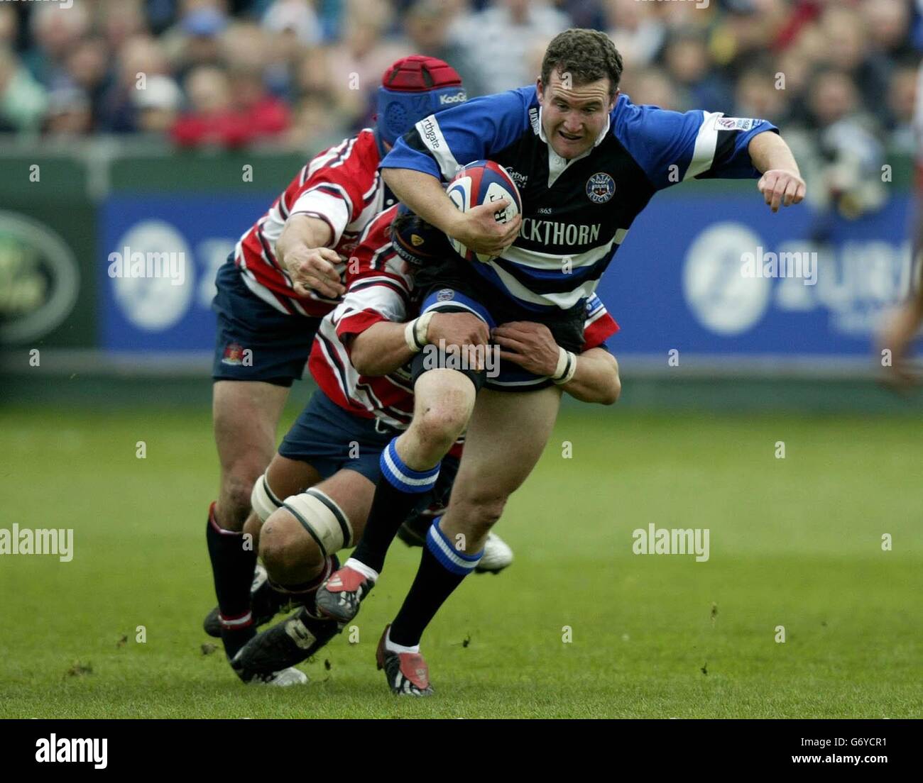 Chris Malone of Bath tries to escape the tackle of Gloucester's Alex ...