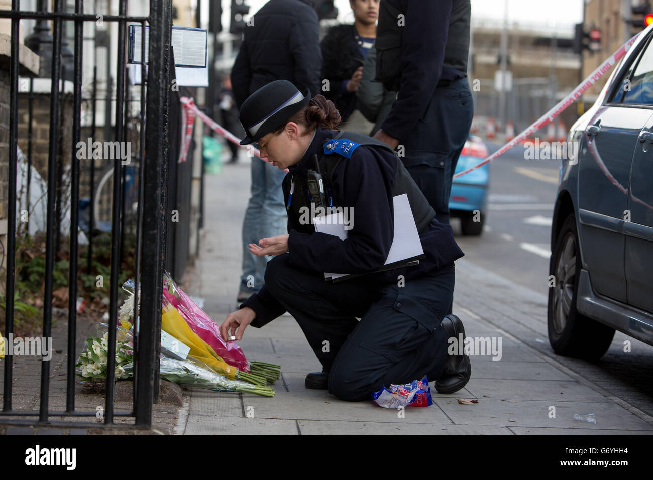 A police community support officer lays flowers handed to her at the ...