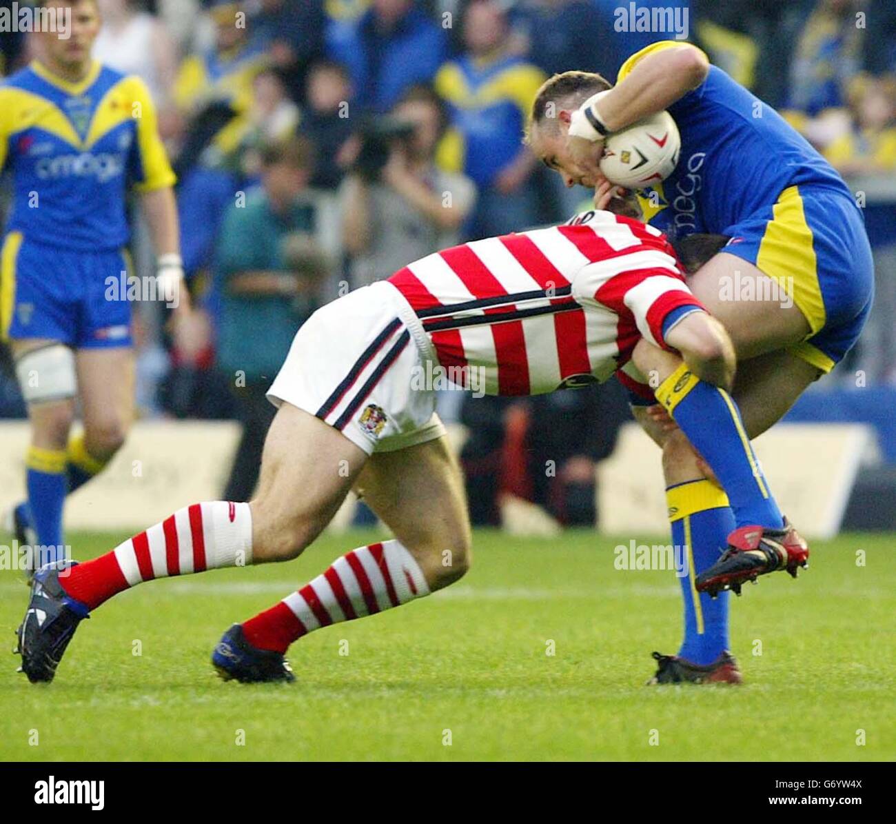 Warrington's Daryl Cardiss is charged down by Wigan's Craig Smith ...