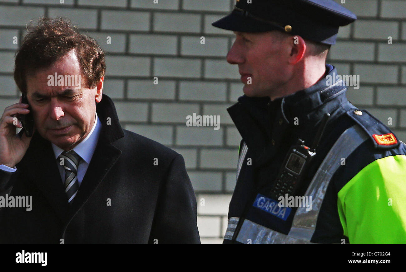 Justice Minster Alan Shatter takes a phone call after the funeral mass ...