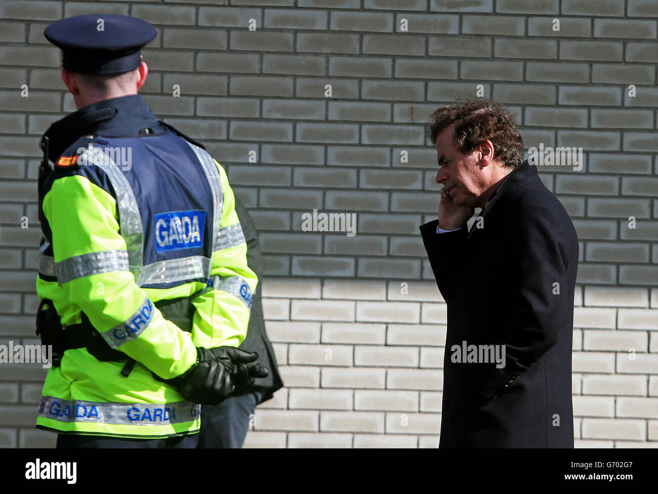 Justice Minster Alan Shatter takes a phone call after the funeral mass ...