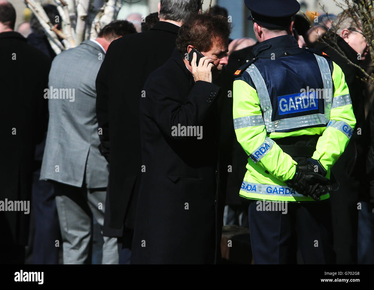 Justice Minster Alan Shatter takes a phone call after the funeral mass ...