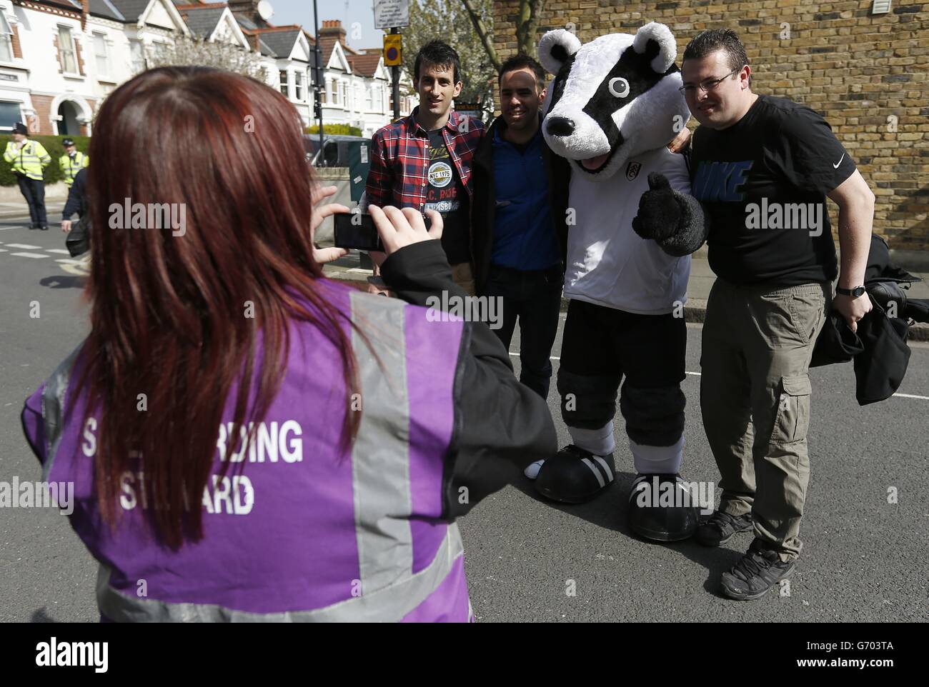 Fulham fans pose for a photo with mascot Billy Basger at Craven Cottage ...