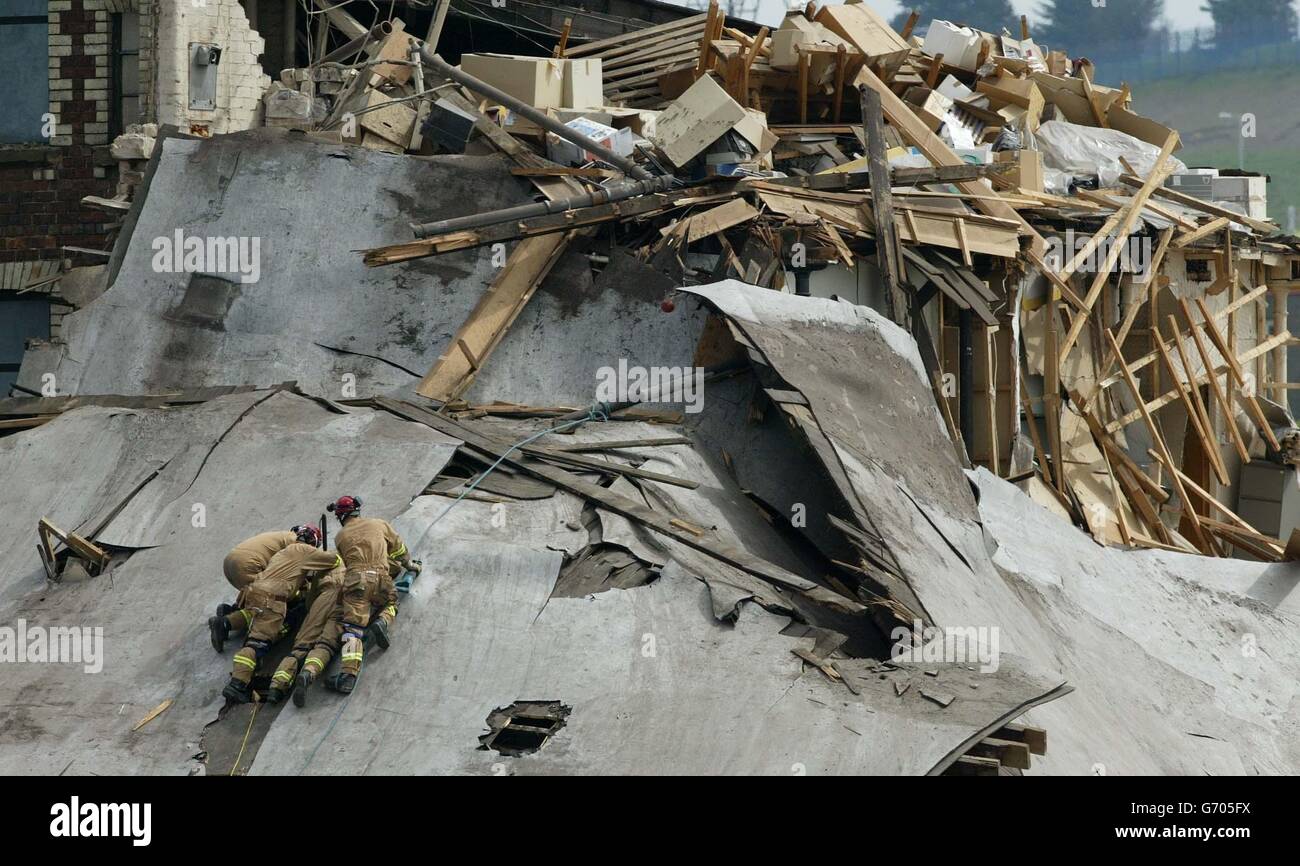 Rescue workers scale the roof in a bid to find survivors at the ...