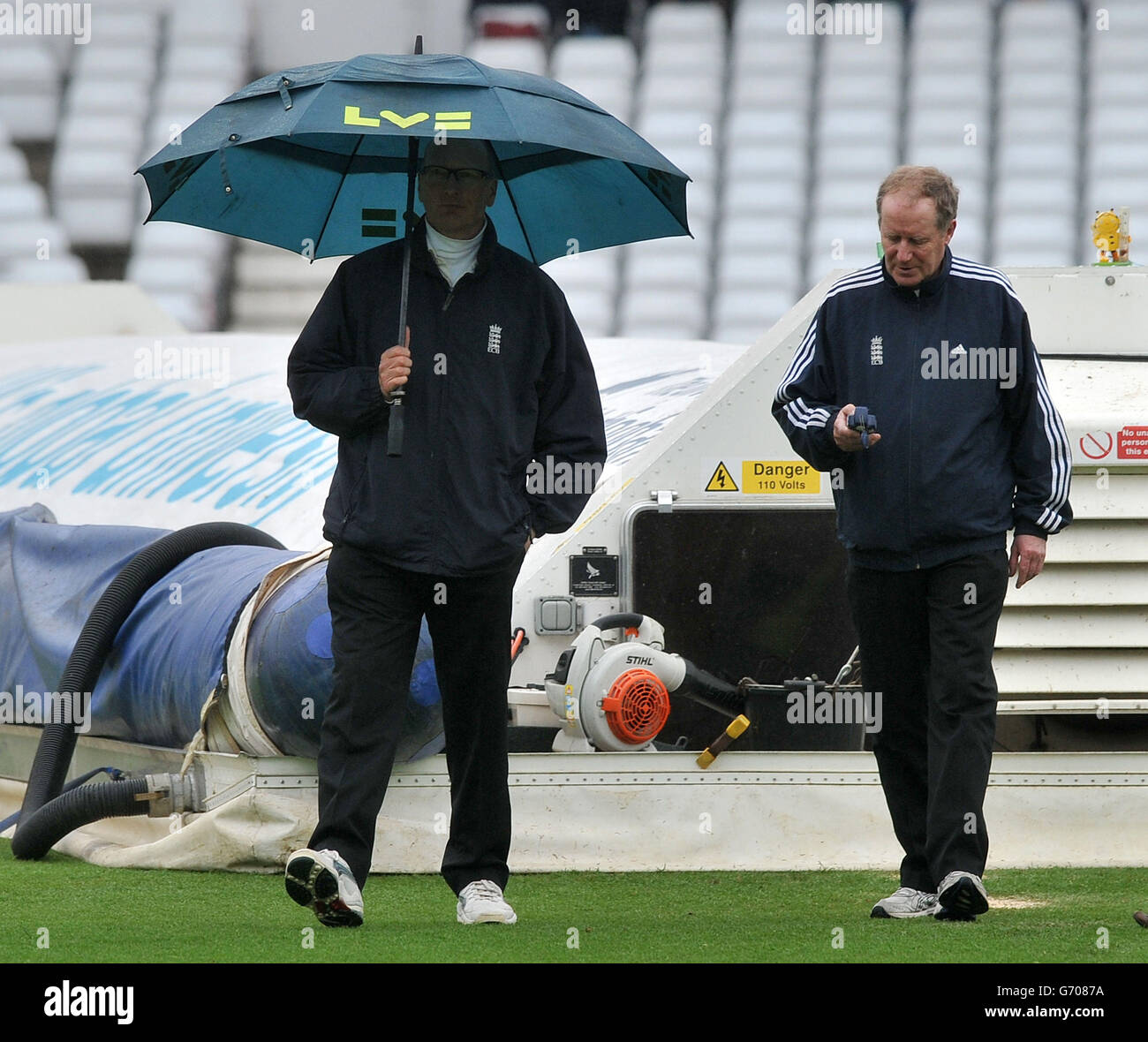 Umpires Stephen Gale (right) and Neil Mallender inspect the pitch as ...