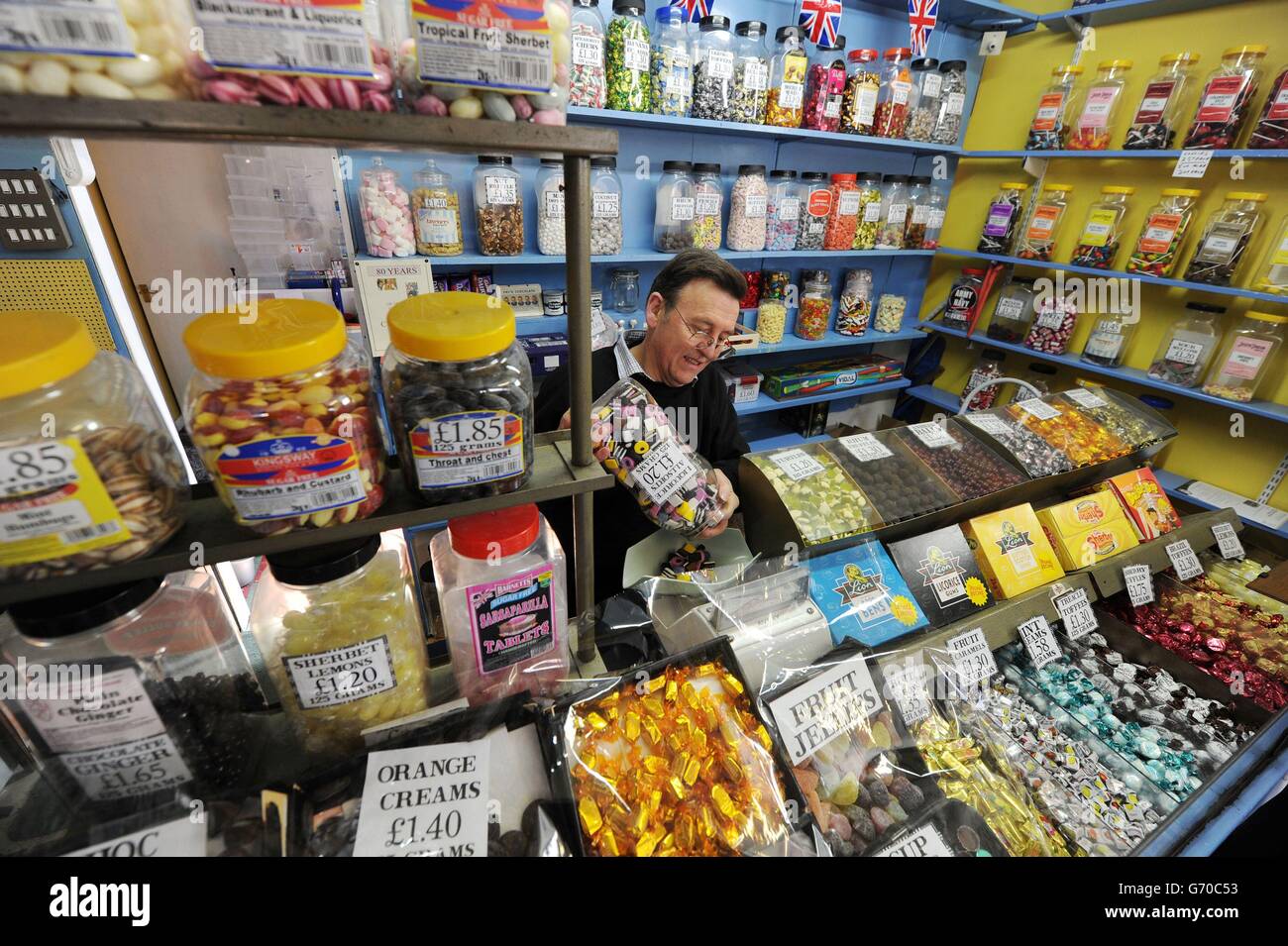 Alan Clough weighs out some sweets in his shop Clough's of Heaton as he ...