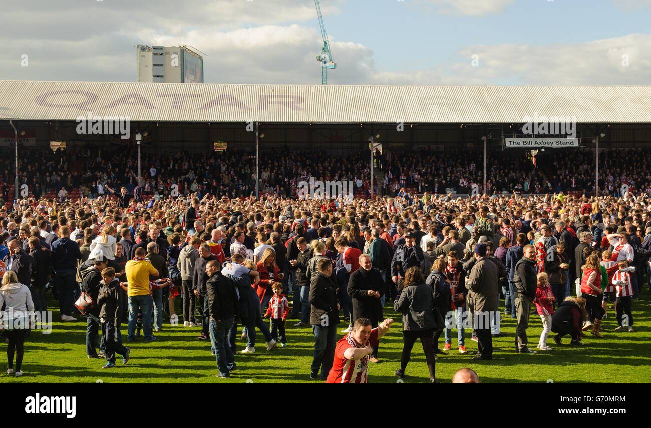 Brentford fans celebrate on the pitch after winning promotion to the ...