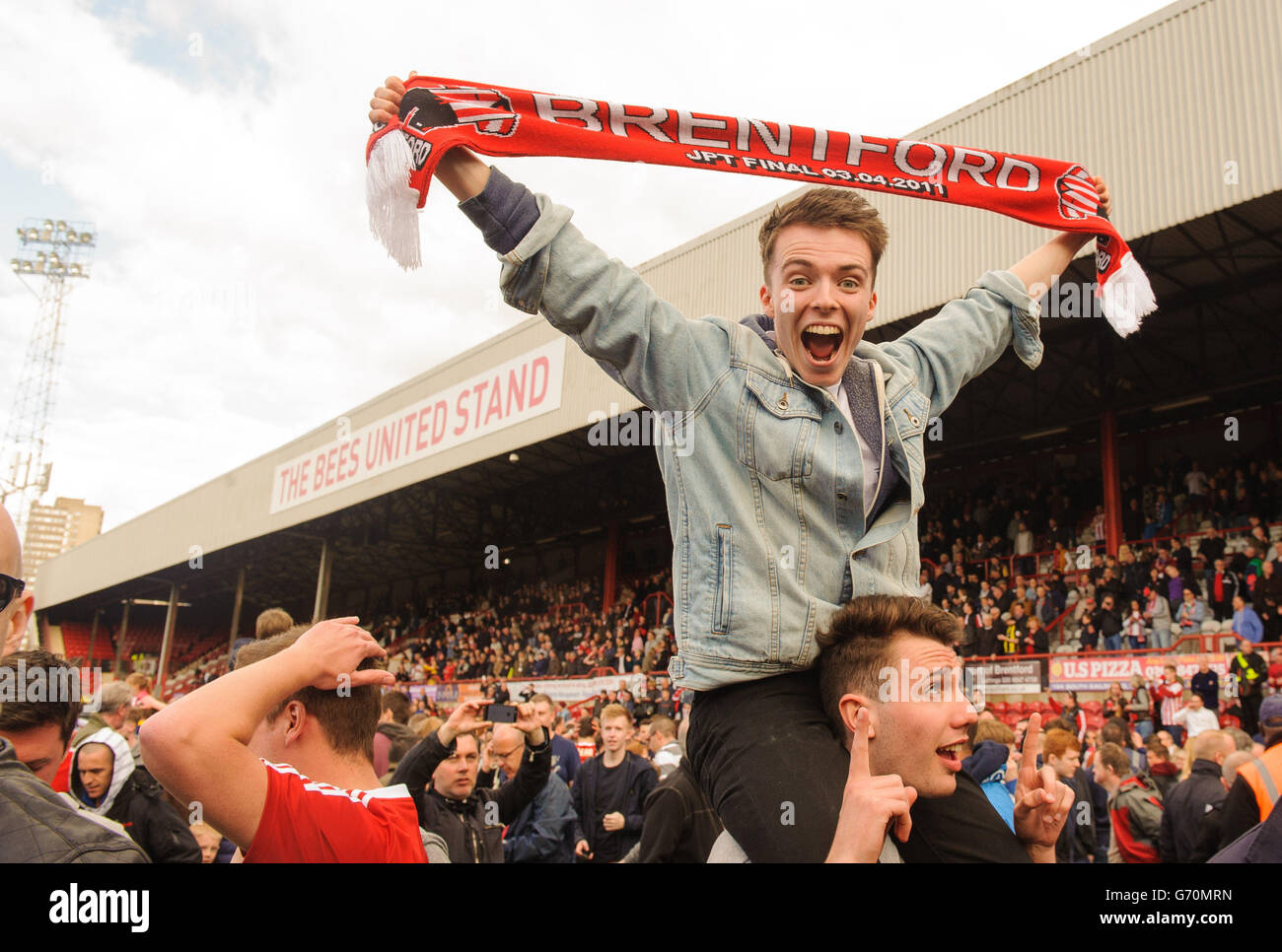 Brentford fans celebrate on the pitch after winning promotion to the ...