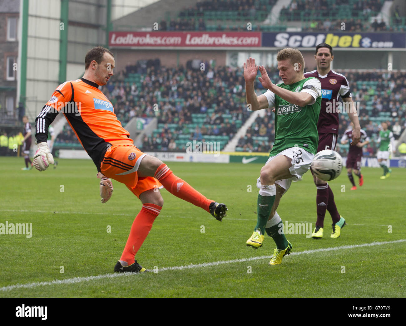 Hearts' goalkeeper Jamie McDonald (left) clears from Hibernian's Jason ...