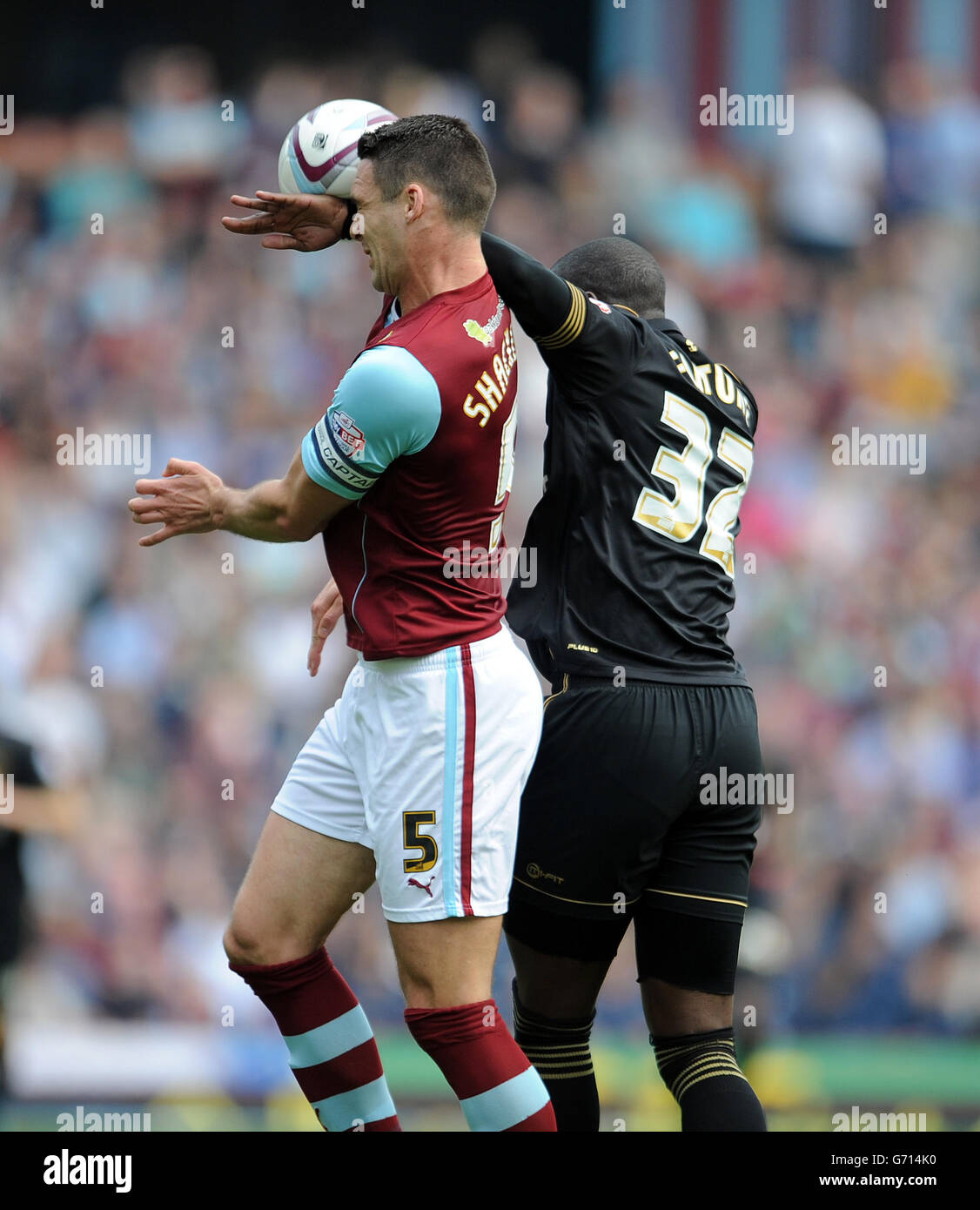 Burnley's Jason Shackell (left) is hit in the face by the arm of Wigan ...