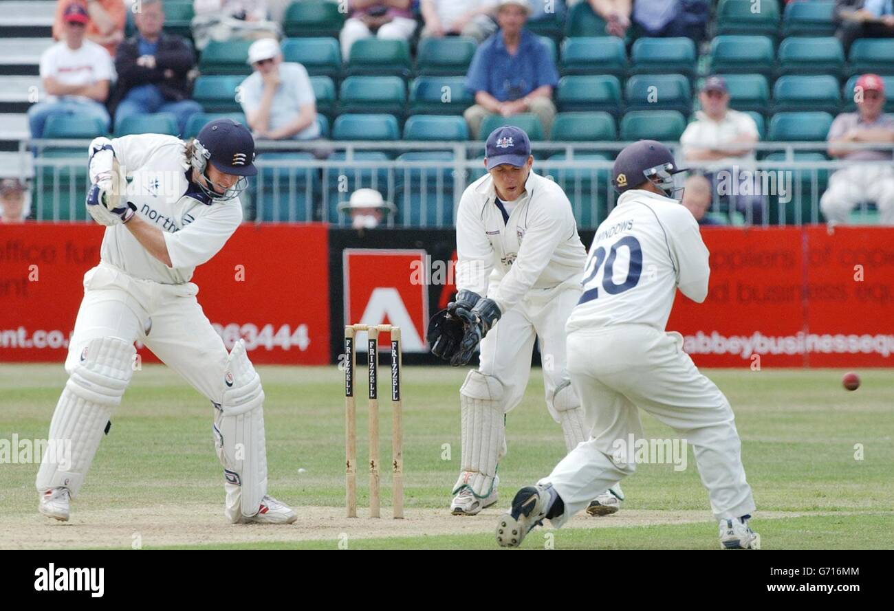Ed Joyce of Middlesex (left) hits a shot past the Gloucestershire pair ...