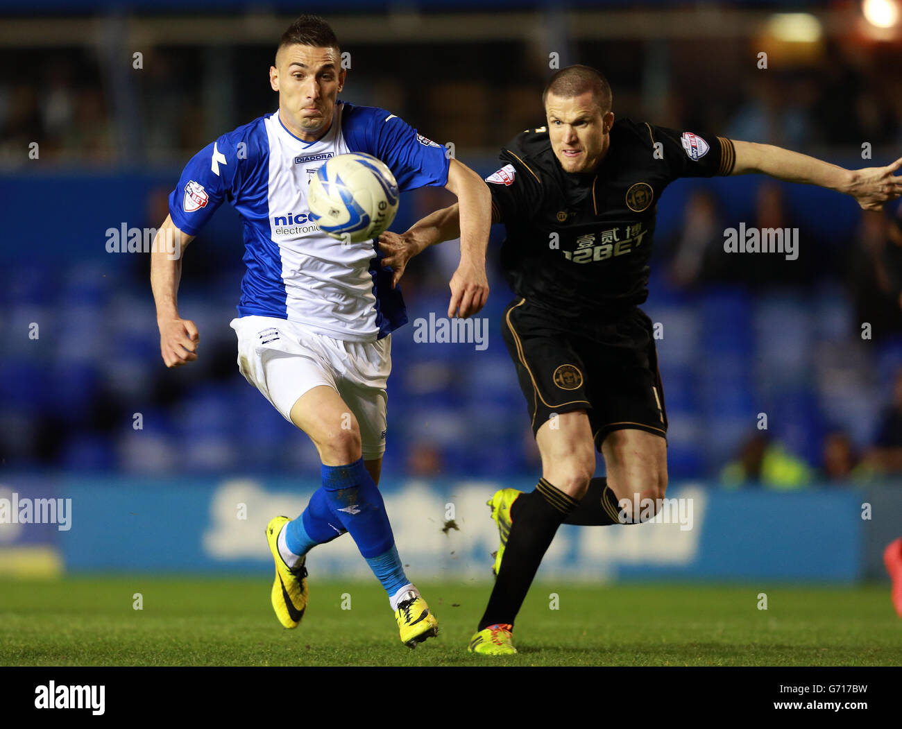 Birmingham City's Federico Macheda holds off Wigan's Gary Caldwell ...